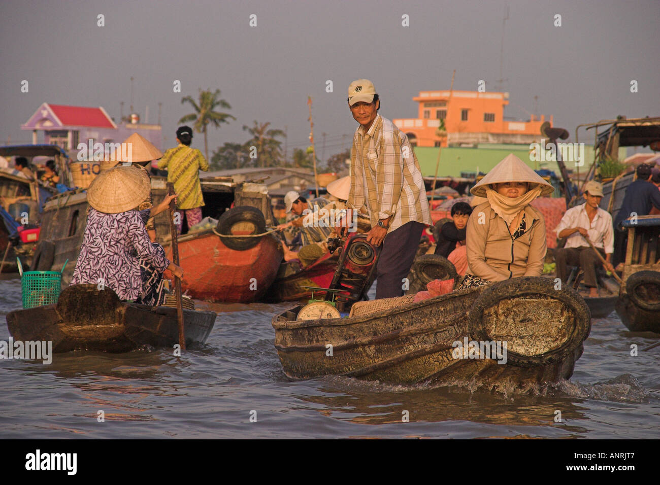 A family skillfully weave through the crowd at the floating market ...