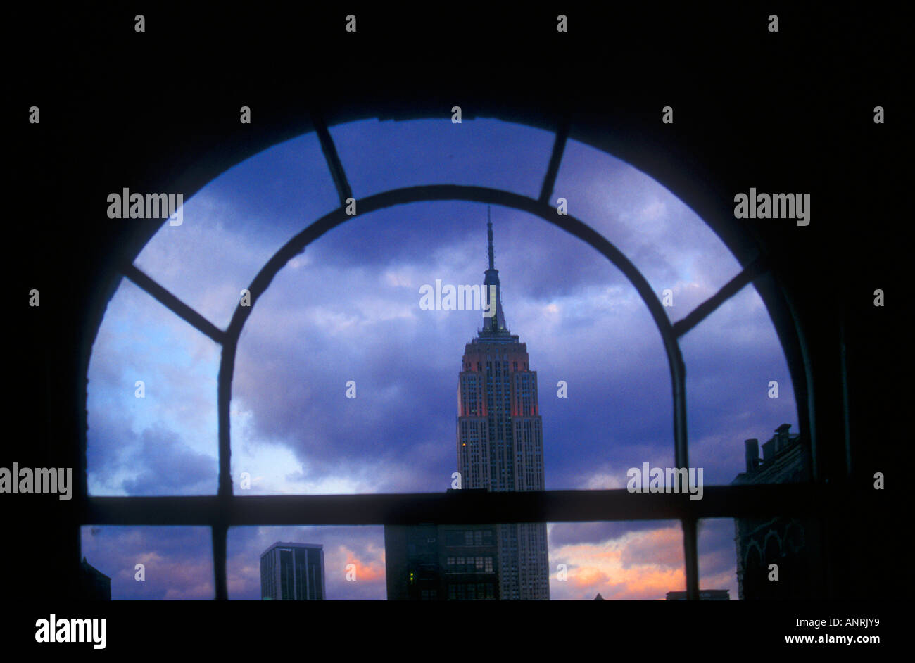 New York NY The Empire State Building framed by a window in a Manhattan ...