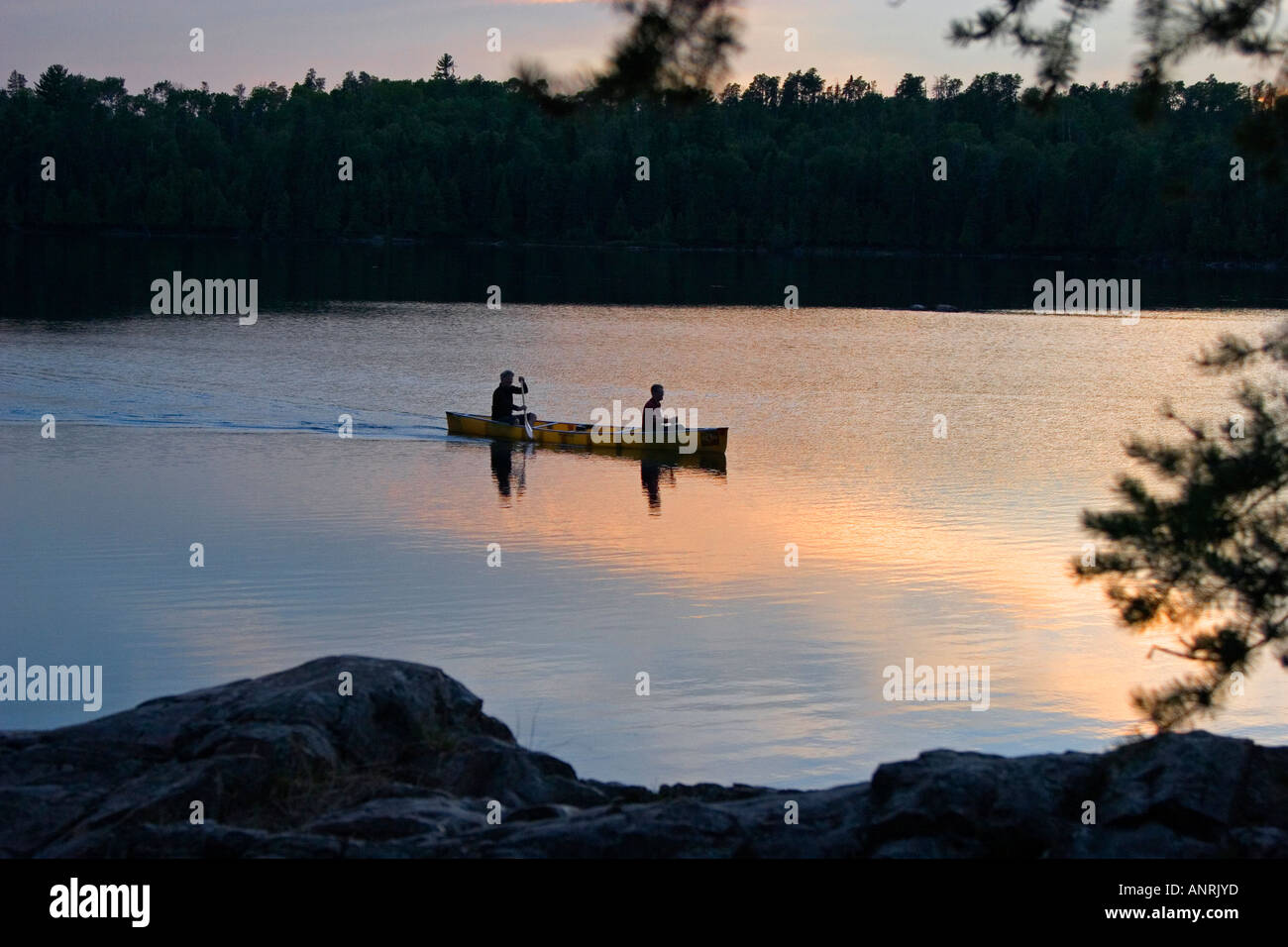 Quetico Provincial Park Ontario Canoers paddle on Agnes Lake at dusk ...