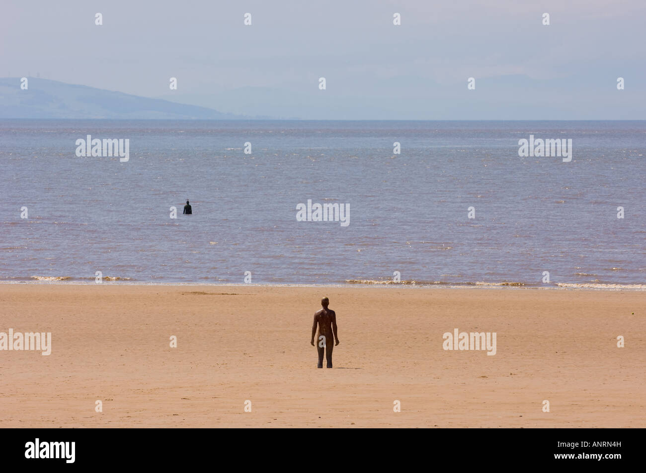 Iron Man sculpture on the soft sand of Crosby Beach looking out to sea ...