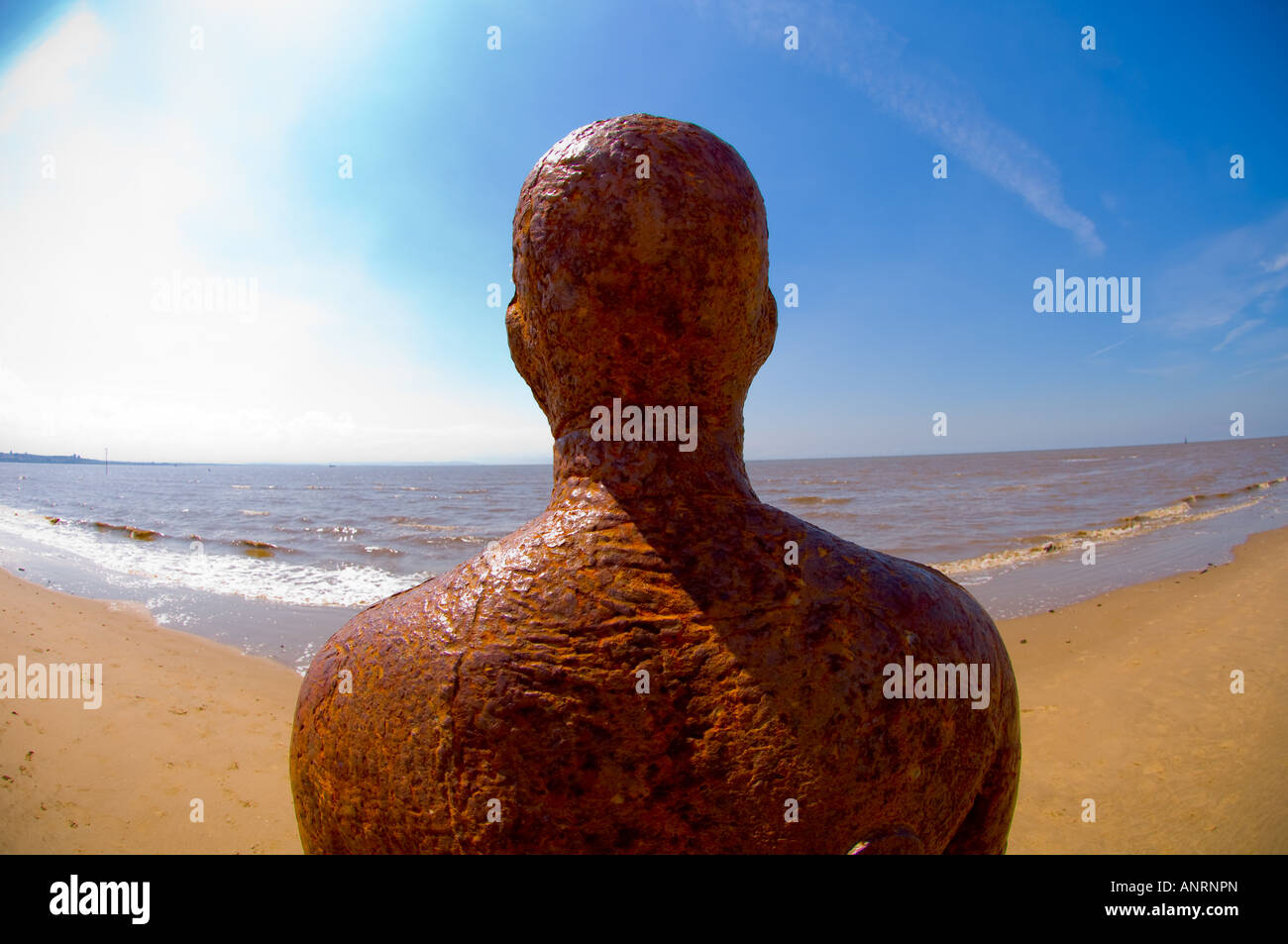 Another Place by Antony Gormley. Rear view of rusty cast iron man ...