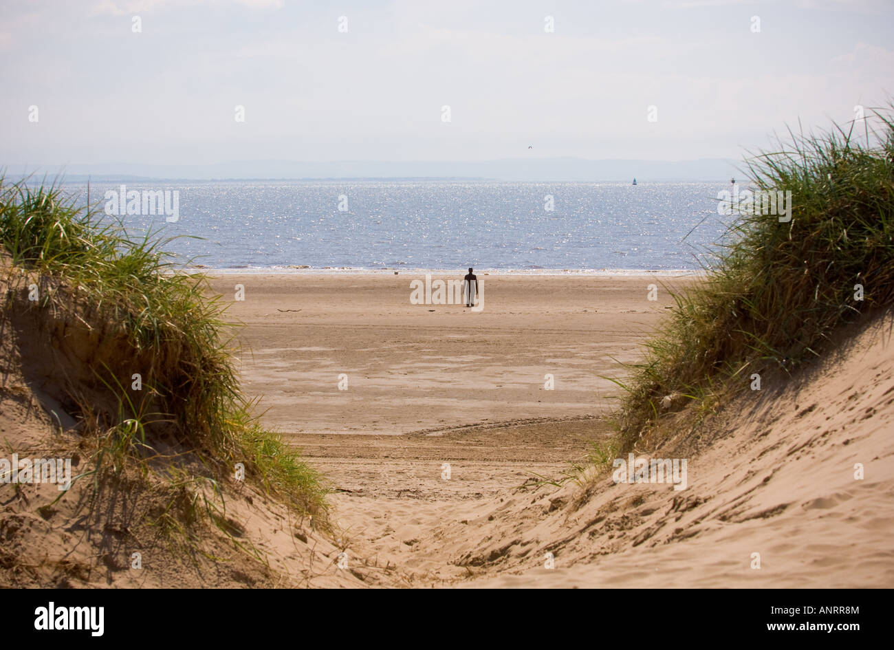 An iconic Another Place, cast Iron Man statue stands amidst the sand ...