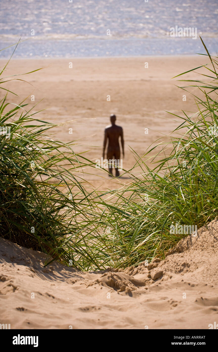 An iconic Another Place, cast Iron Man statue stands amidst the sand ...