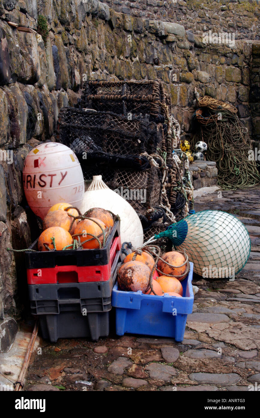 Buoys and floats stacked against harbour wall, Clovelly, Devon, England ...