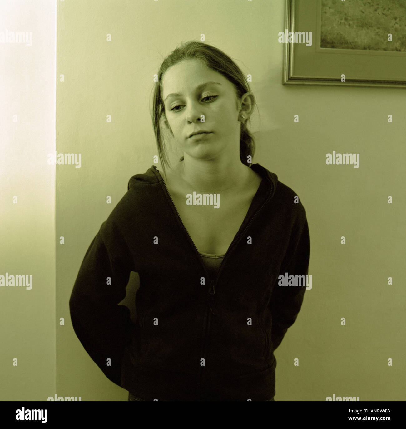 Teenage girl standing by wall Stock Photo - Alamy