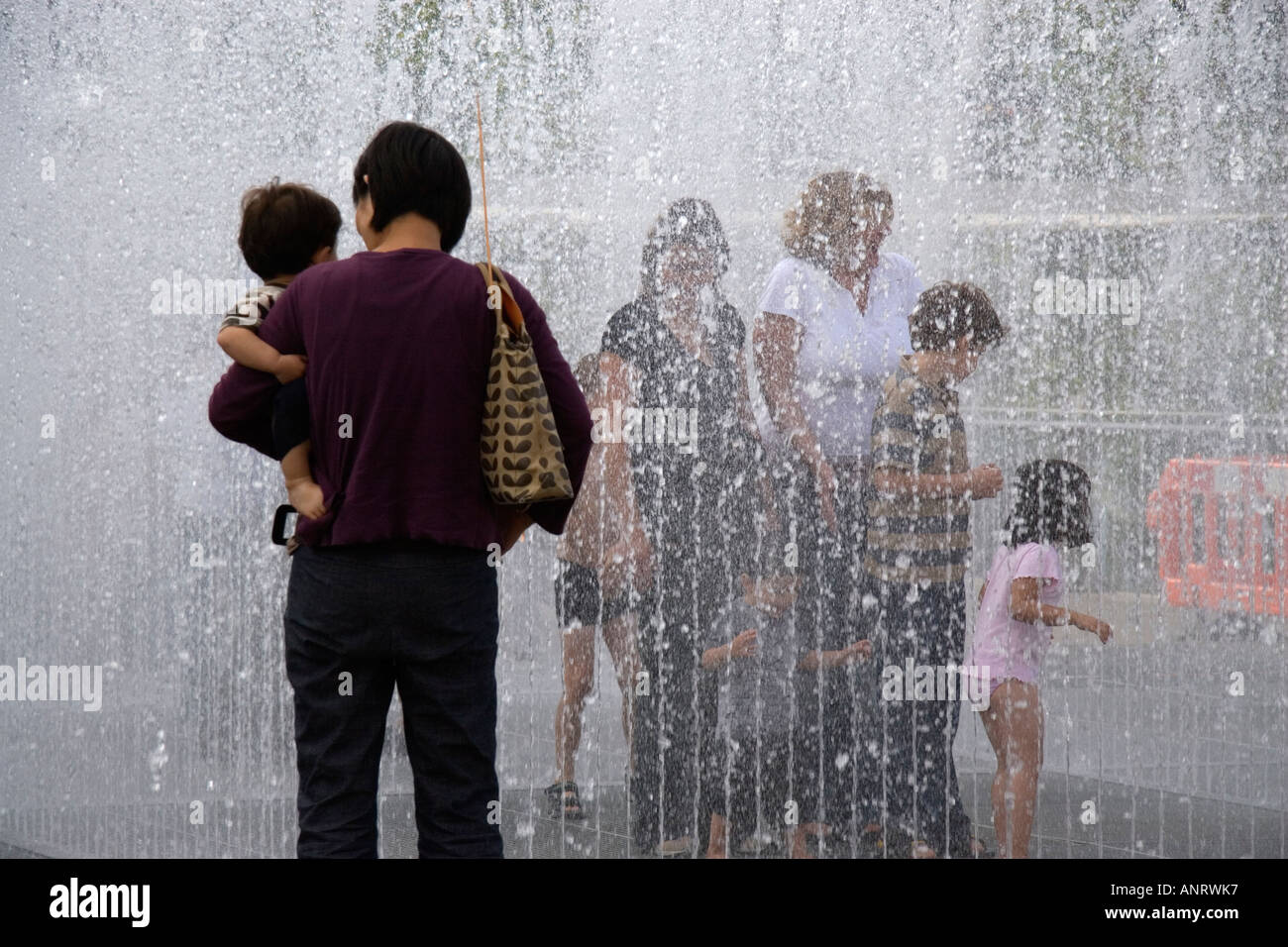 Woman playing in water fountain hi-res stock photography and images - Alamy