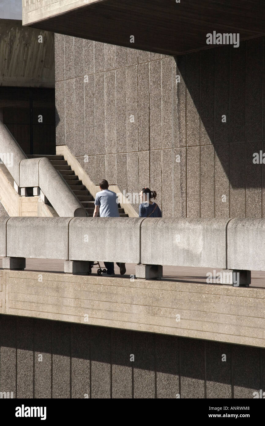 A couple walking amongst the brutalist architecture of the South Bank ...
