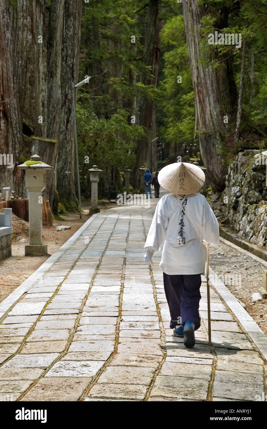 A pilgrim walks the path through the forest graveyard at Okunoin temple ...