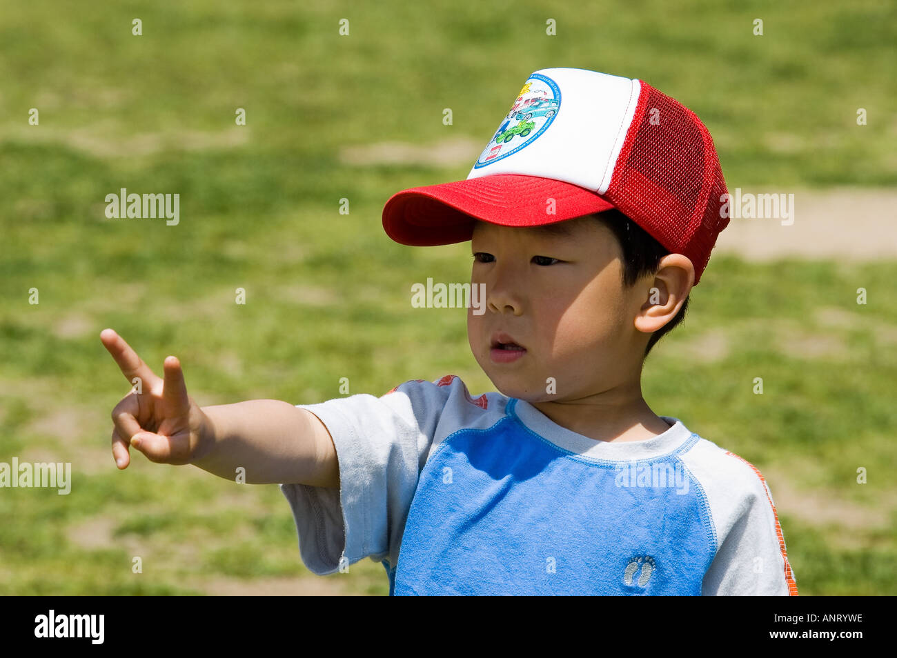 A young Japanese boy gives the peace sign as he poses for a photograph ...