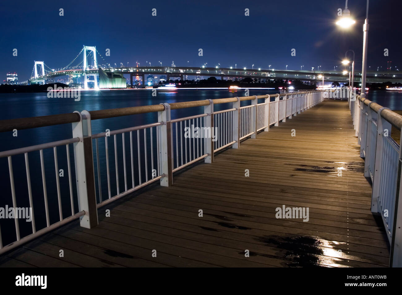 Stock photo of a short pier in front of the Rainbow Bridge at night in ...