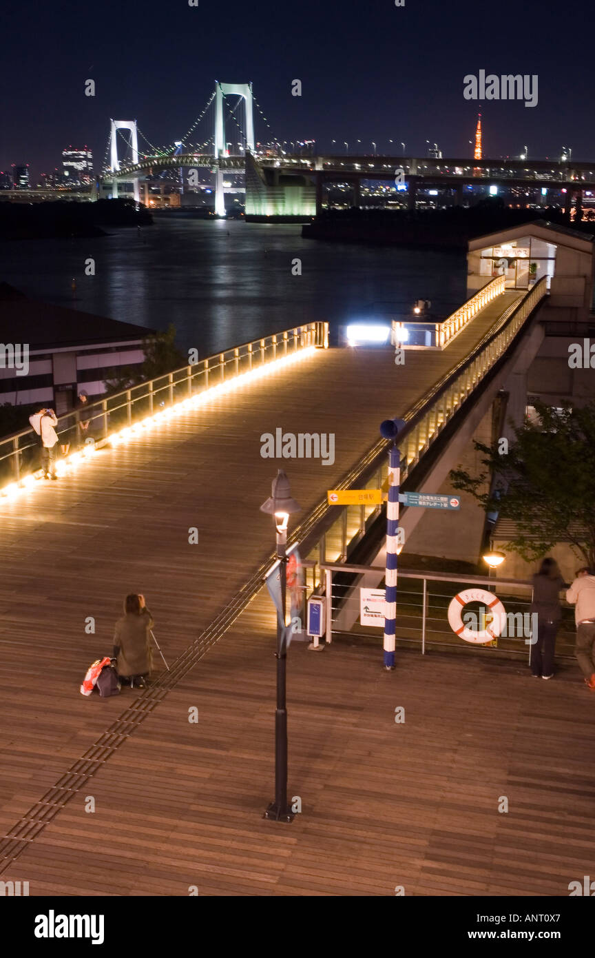 Stock photo of a short pier in front of the Rainbow Bridge at night in ...