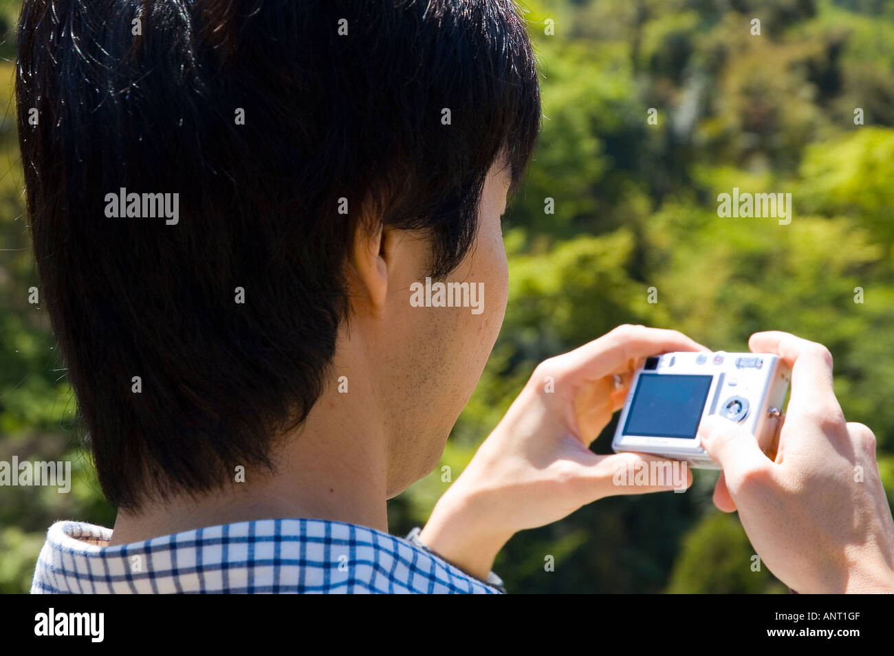 Stock photo of a Japanese man taking a photograph with a digital camera ...