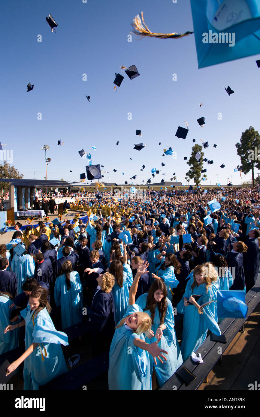Graduating high school seniors throw their traditional caps in the air ...