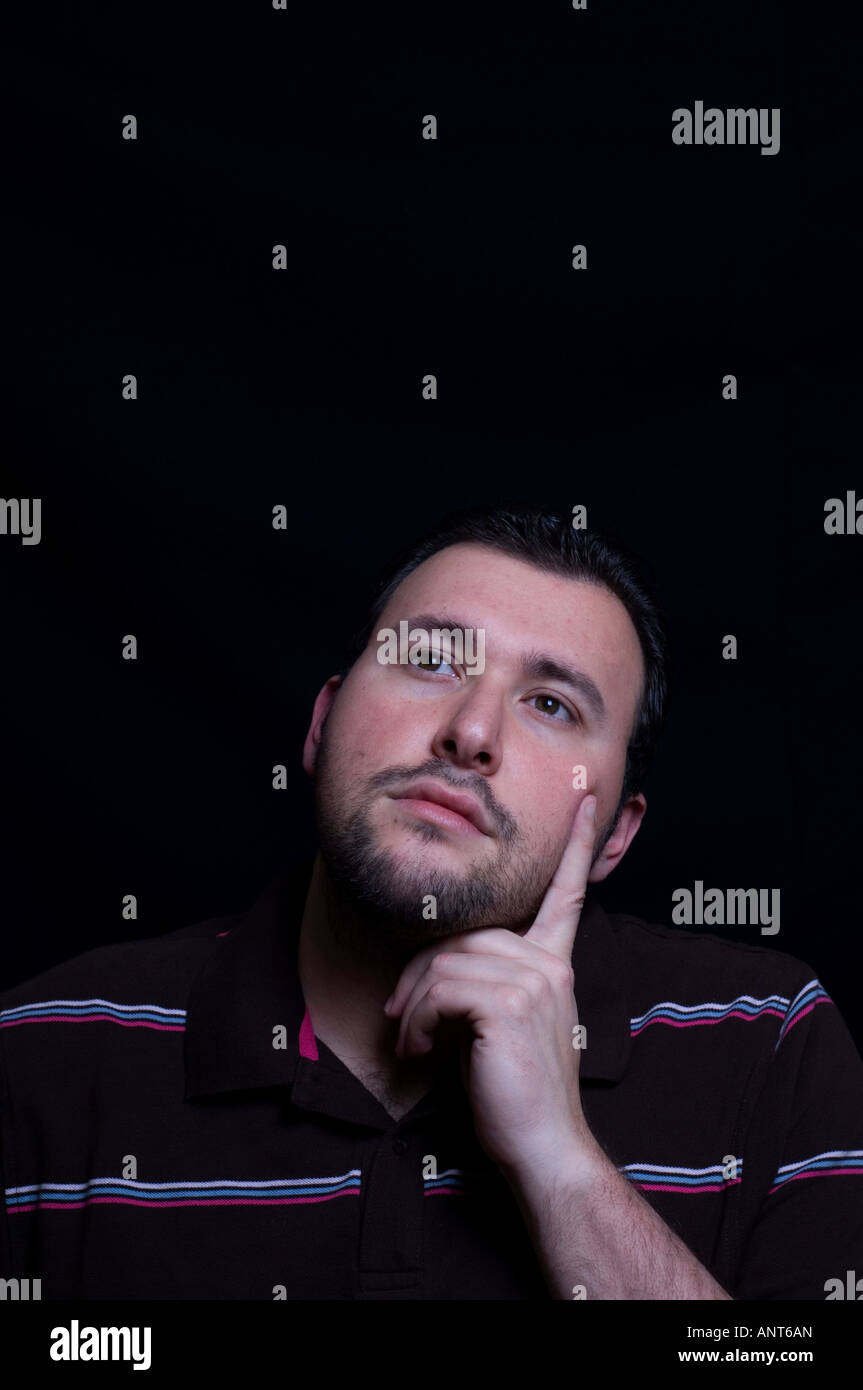 Man hand on face thinking looking up on a black background Stock Photo ...