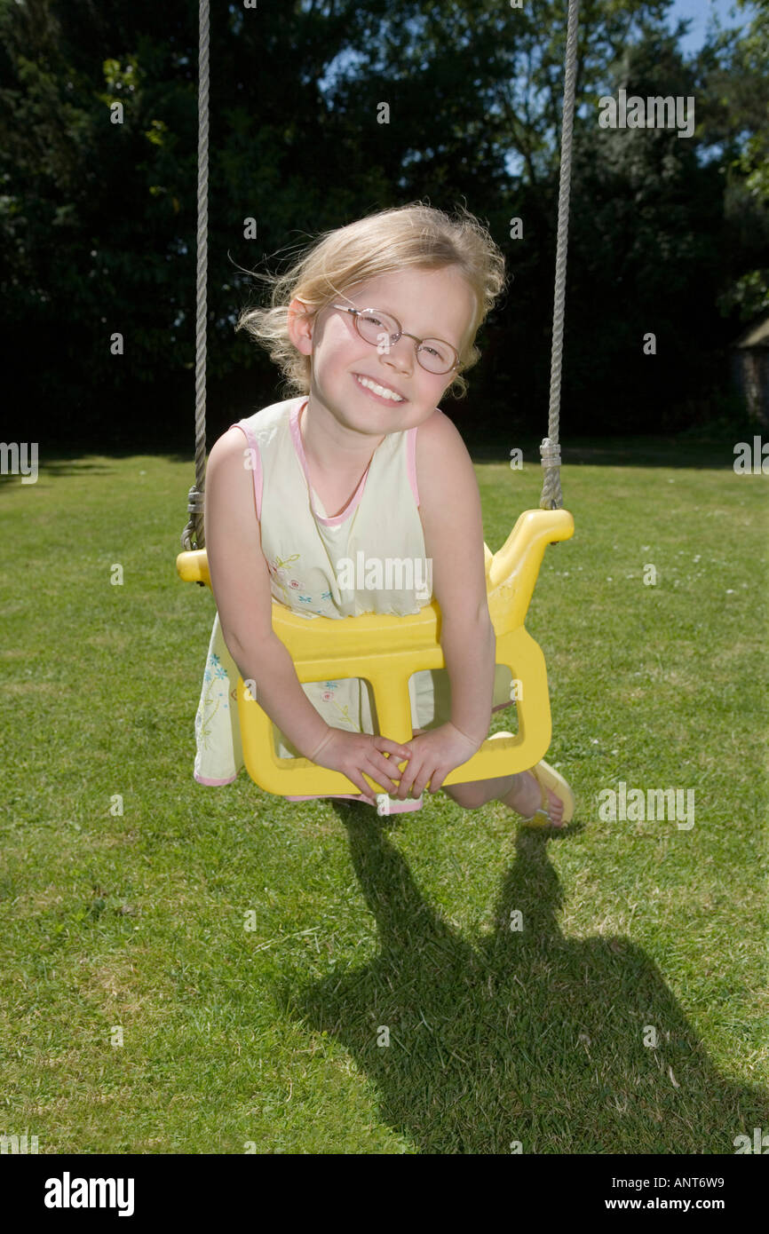 Portrait of young girl lying on swing Stock Photo - Alamy