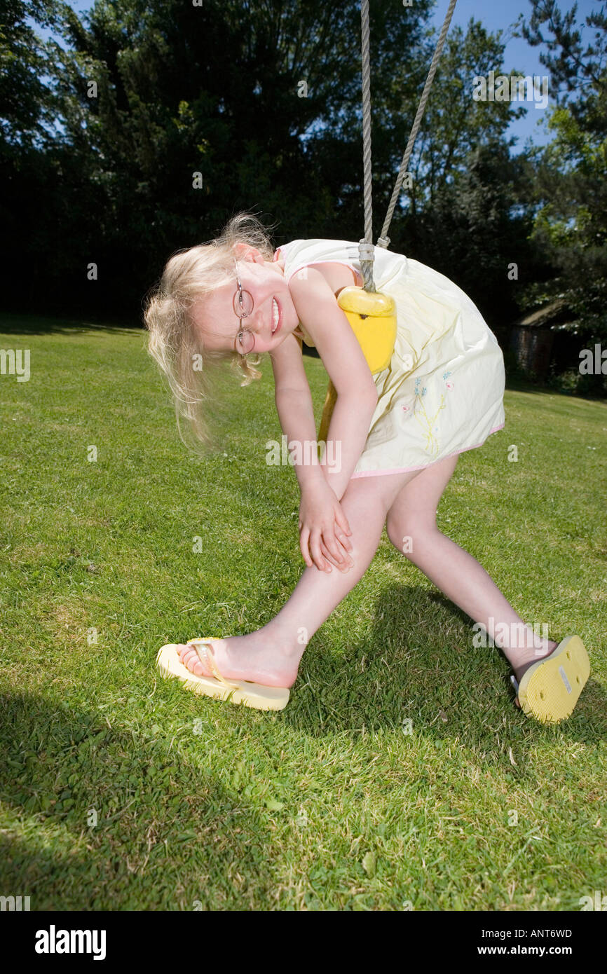 Portrait of young girl lying on swing Stock Photo - Alamy
