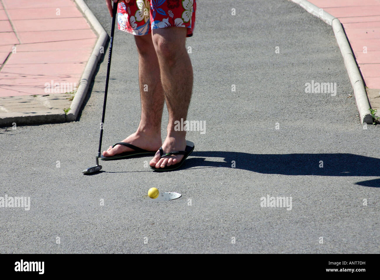 legs of man putting a ball on a crazy golf course Stock Photo - Alamy