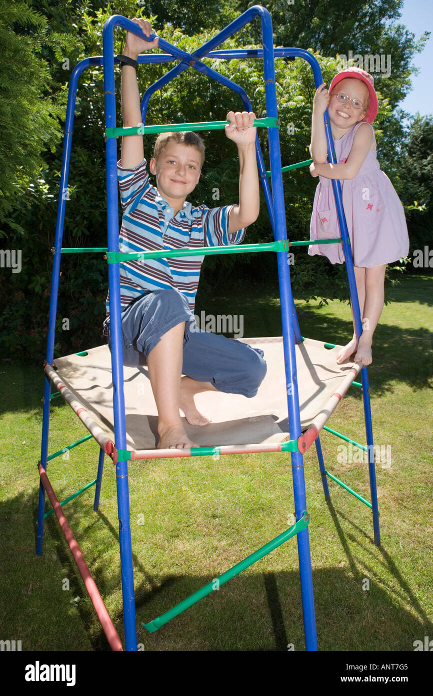 Boy and girl standing on climbing frame Stock Photo - Alamy