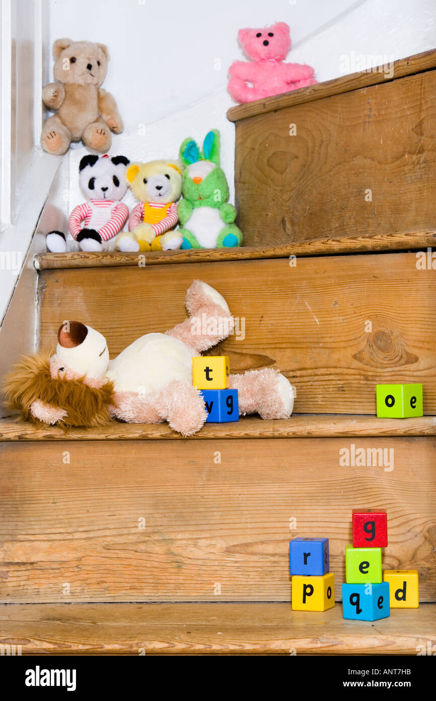 Cuddly toys and alphabet blocks on staircase Stock Photo - Alamy