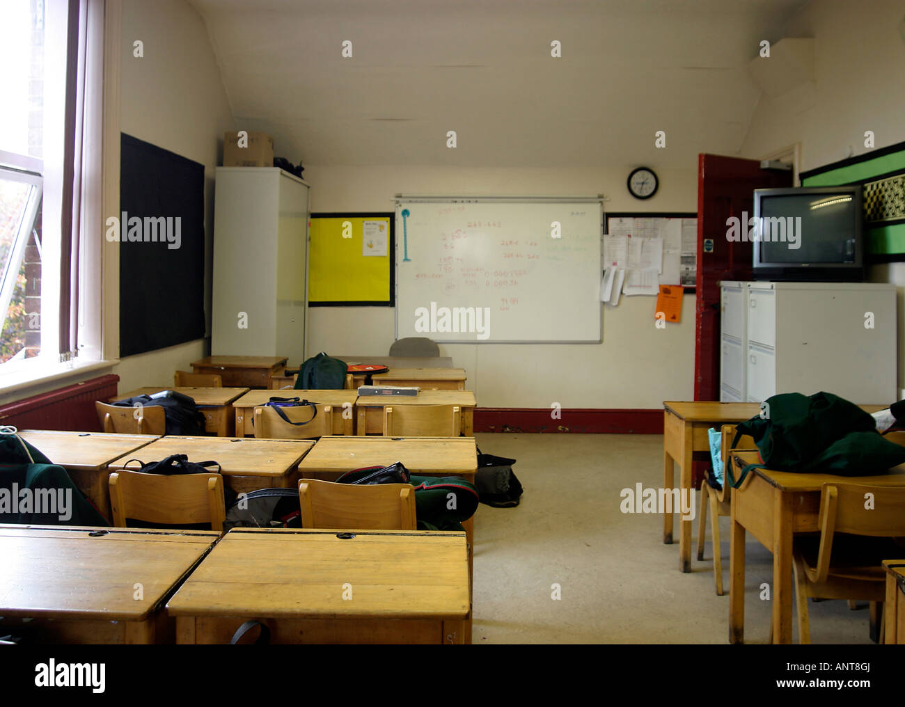 A classroom in a junior school, with tables, chairs and a television in ...