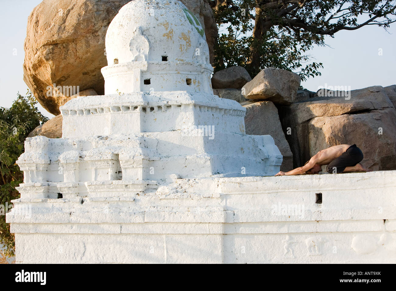 Man performing Hatha Yoga child pose Balasana posture on a hindu temple ...