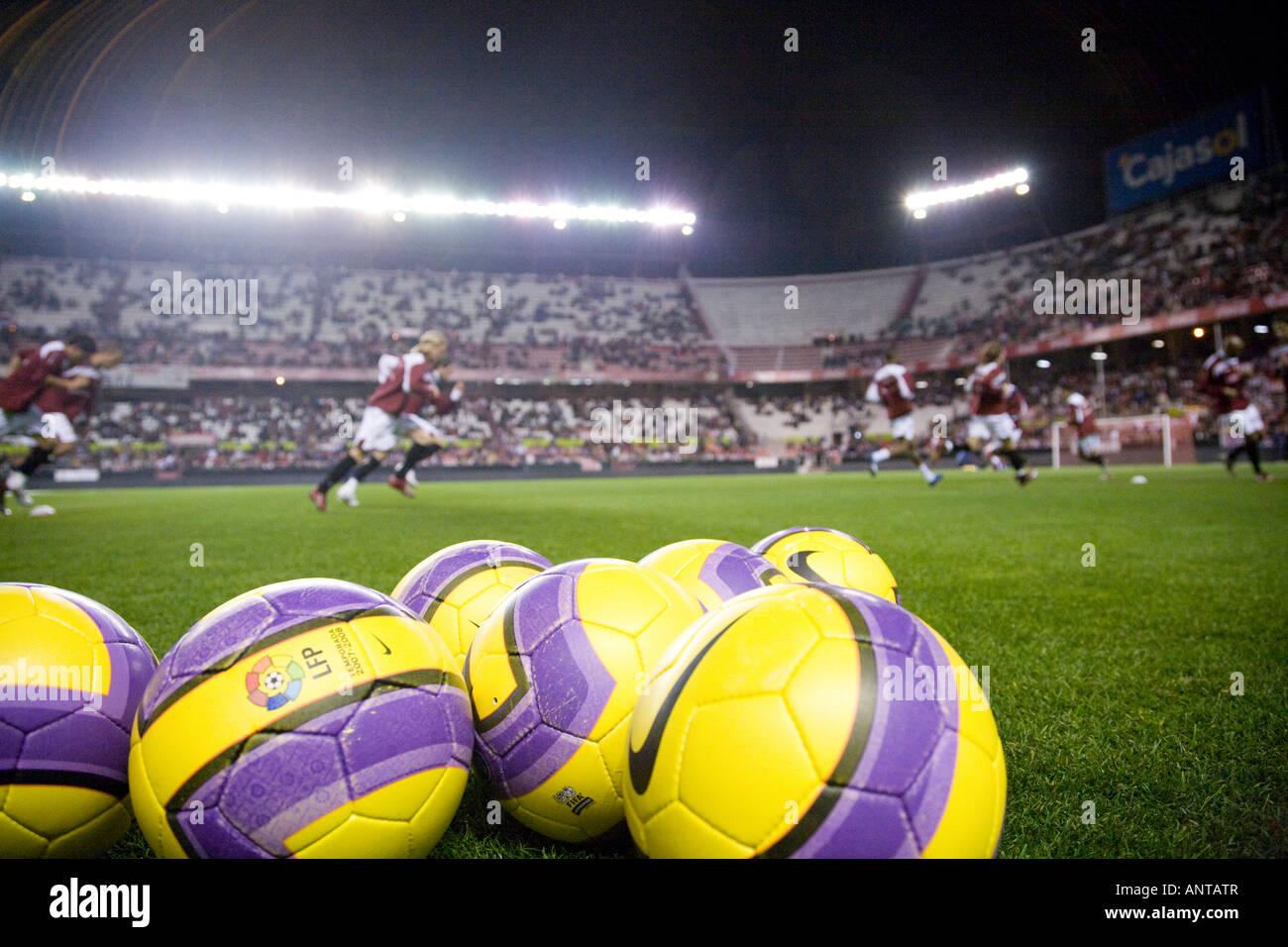 Bunch of football balls and players warming up on the background Stock ...