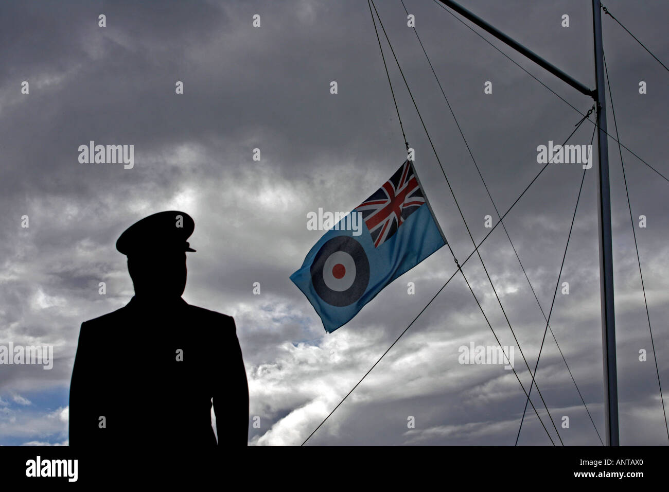 Officer stands under the Royal Ensign at half mast at R.A.F. Kinloss ...