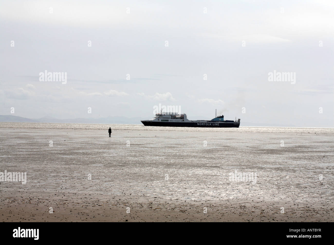 Ferry sailing past Another Place figure sculptures on the beach by ...