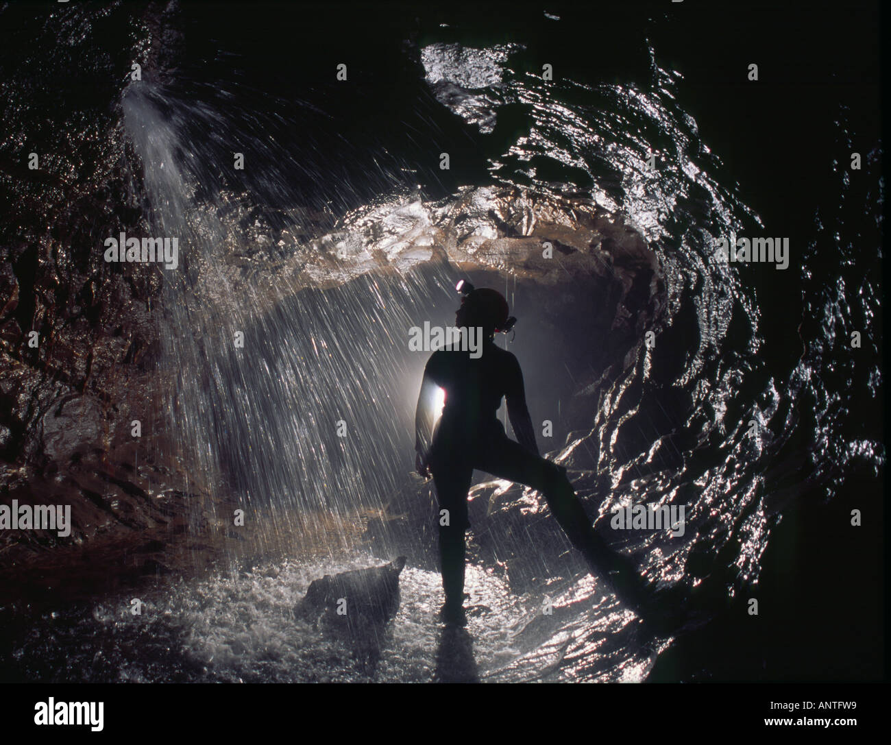 A female caver at a waterfall in the lower series Dan yr Ogof Brecon ...