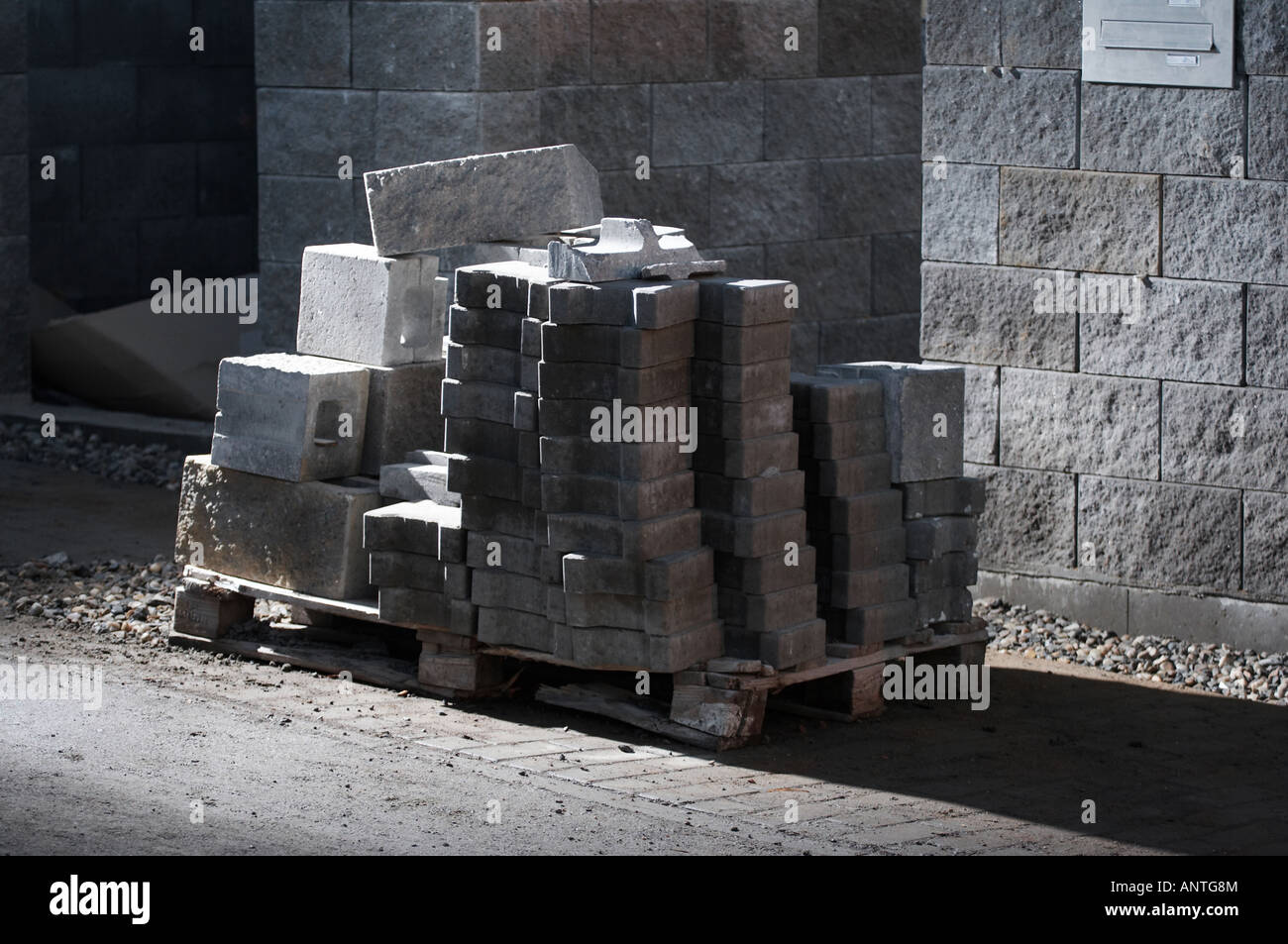 Stacked concrete paving blocks and bricks on a wooden pallet in an ...