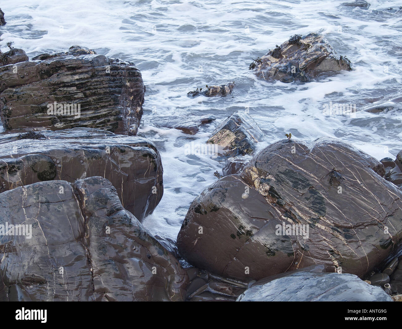 Sea swirling around large rocks Stock Photo - Alamy