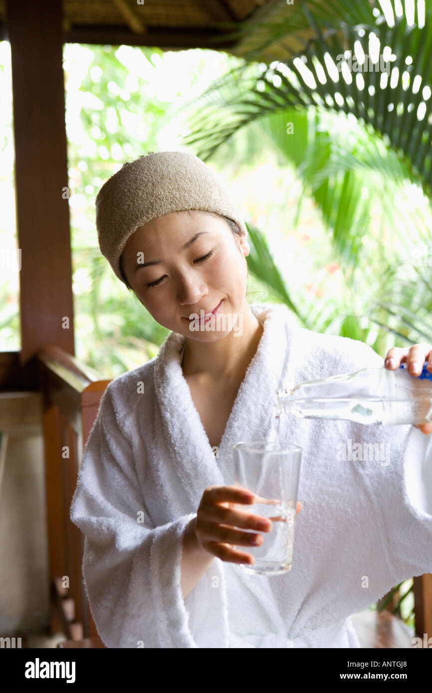 Young woman pouring water into glass Stock Photo - Alamy