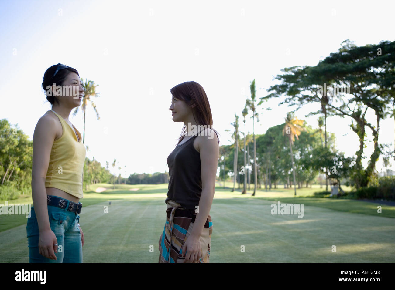 Two young women standing and talking Stock Photo - Alamy