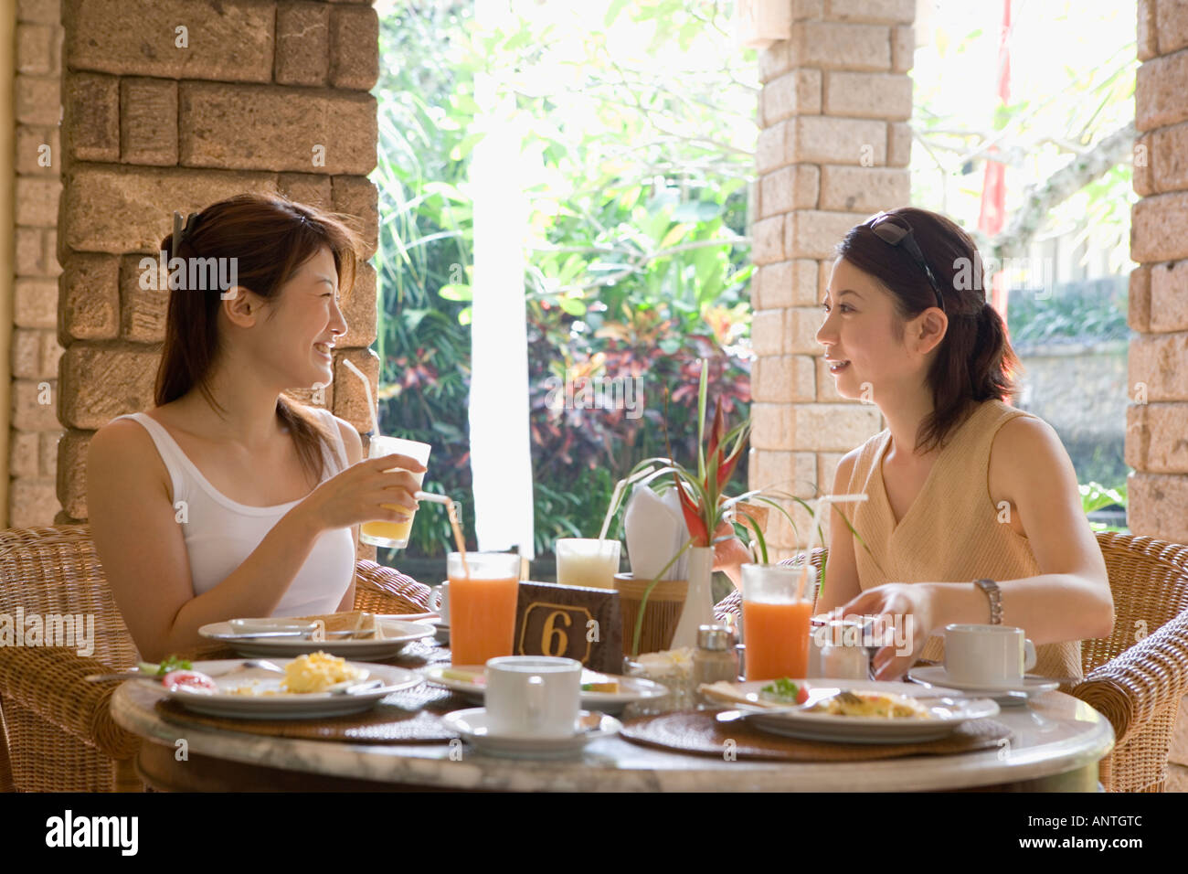 Two young women eating at table Stock Photo - Alamy