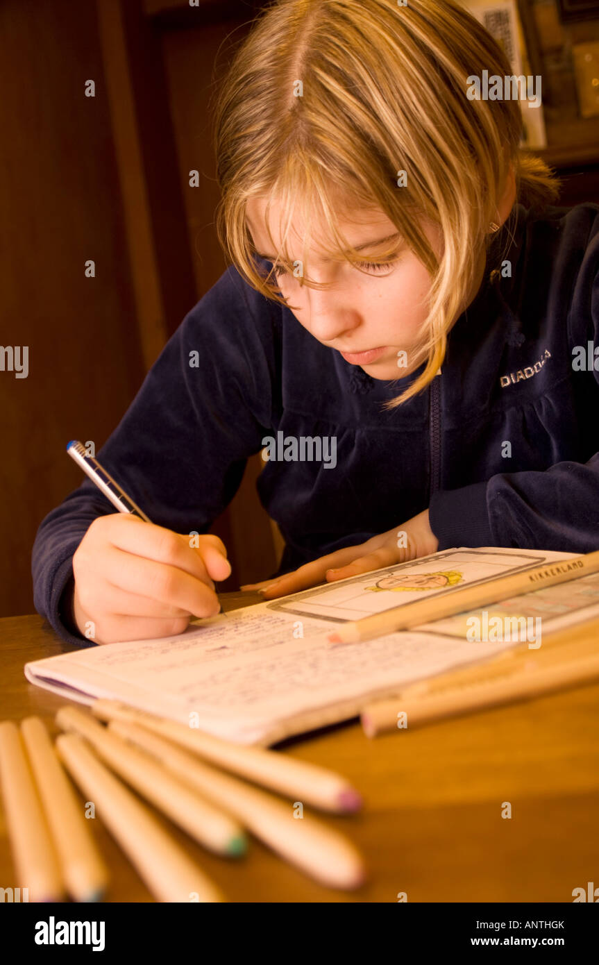 13 year old teenage girl doing her school homework on a table at home ...
