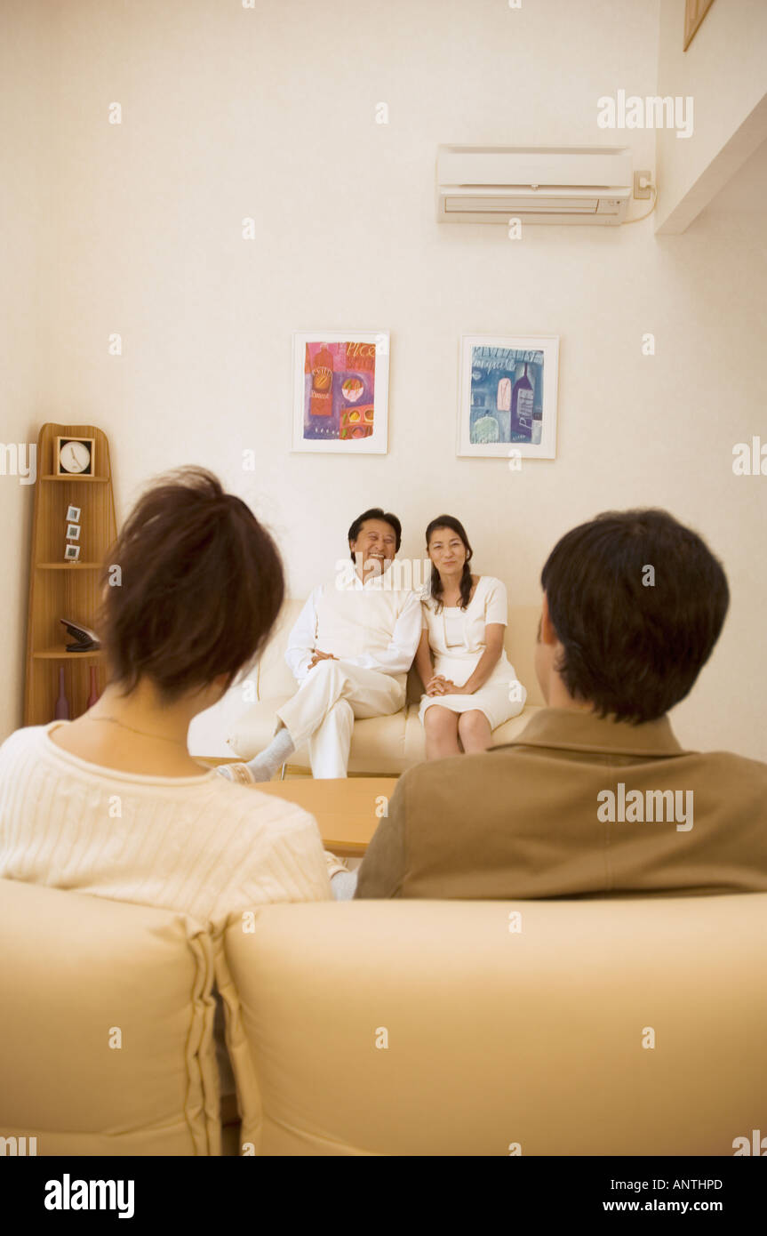 Two mature couples talking in living room Stock Photo - Alamy