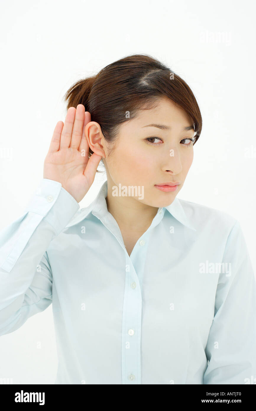 Young woman listening, hand behind ear Stock Photo - Alamy