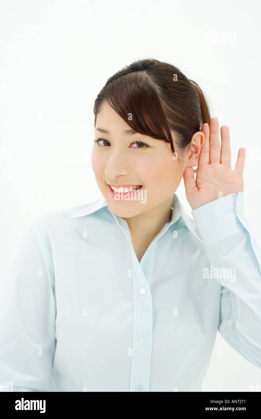 Young woman listening, hand behind ear Stock Photo - Alamy