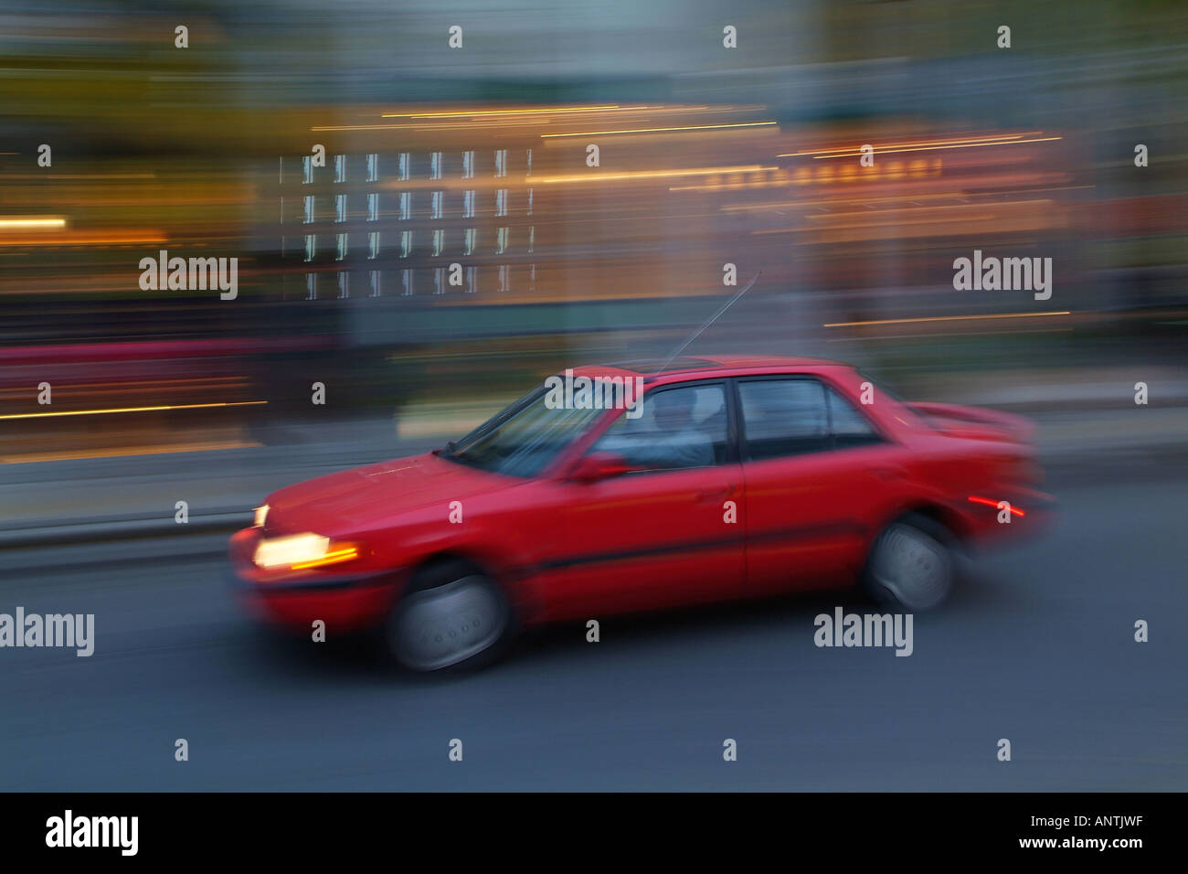Car speeding along a street Stock Photo - Alamy