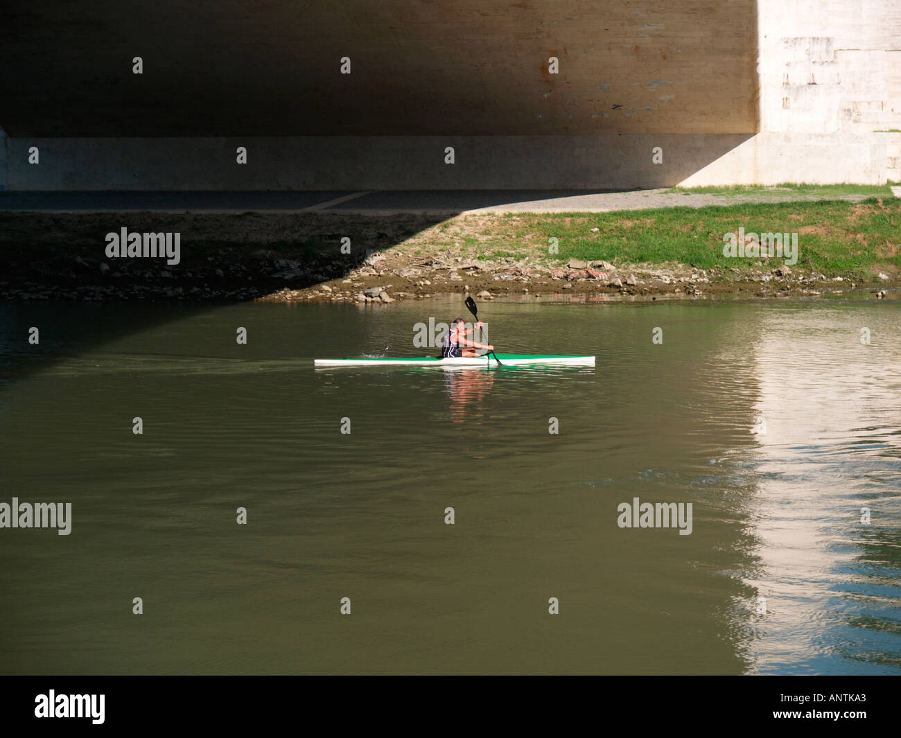 man in canoe passing under bridge Stock Photo - Alamy