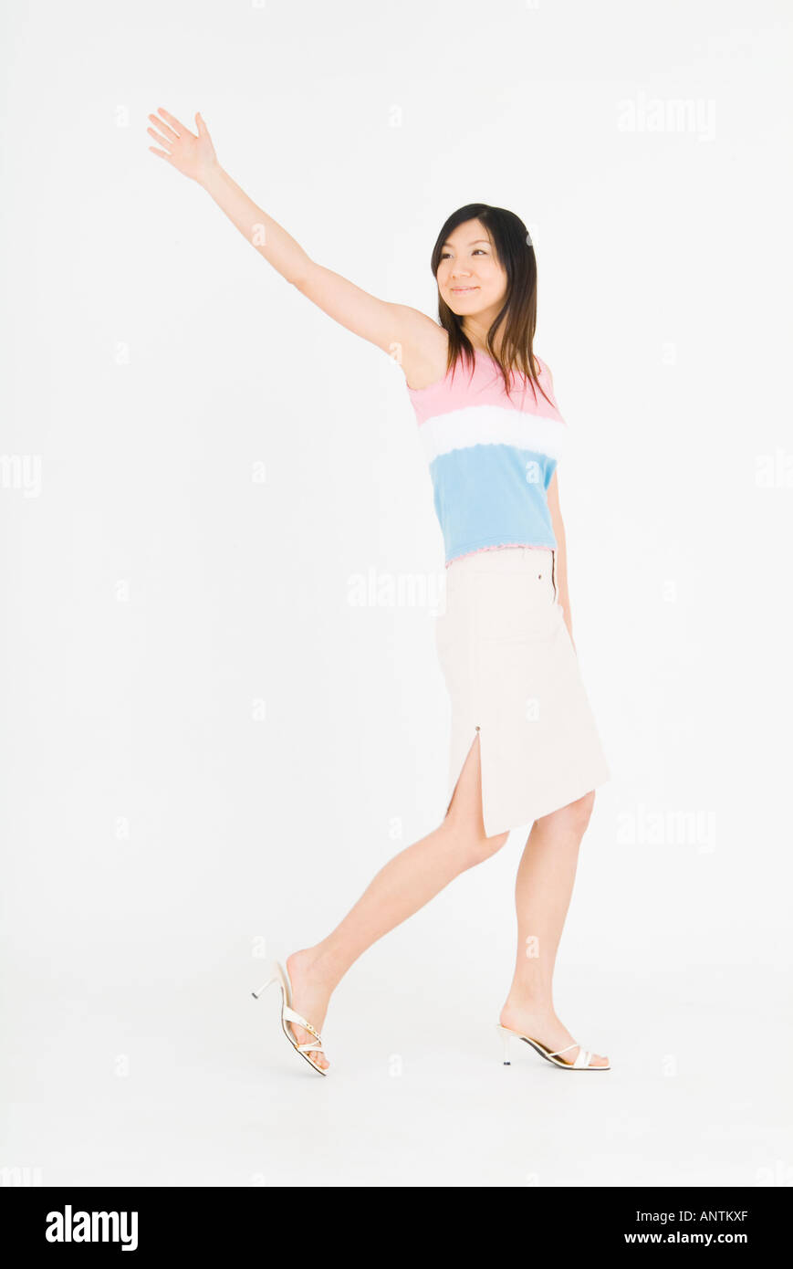 Young woman walking, waving hand Stock Photo - Alamy