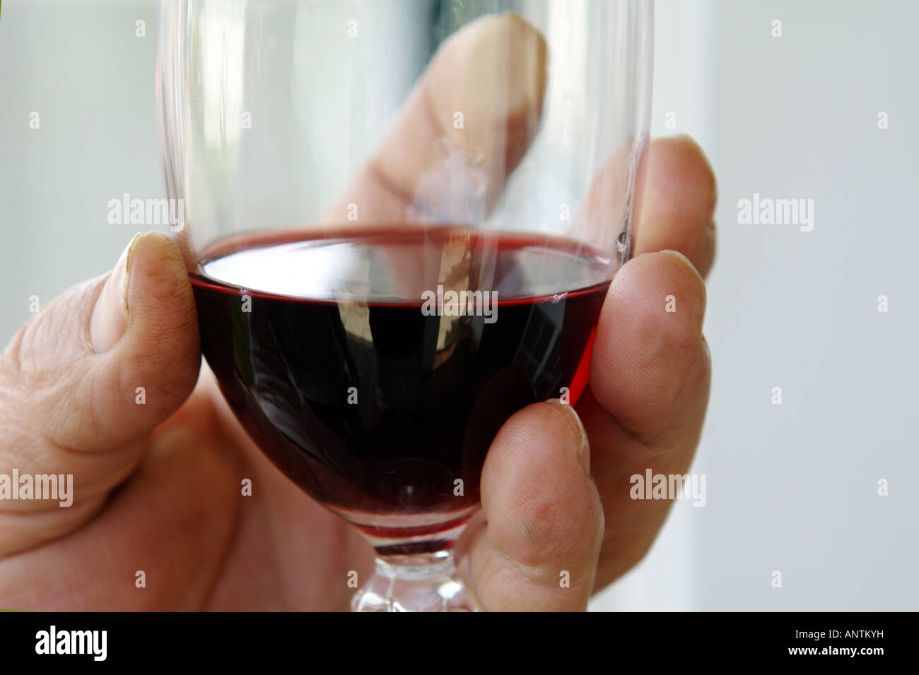 man hand holding glass of red wine Stock Photo - Alamy
