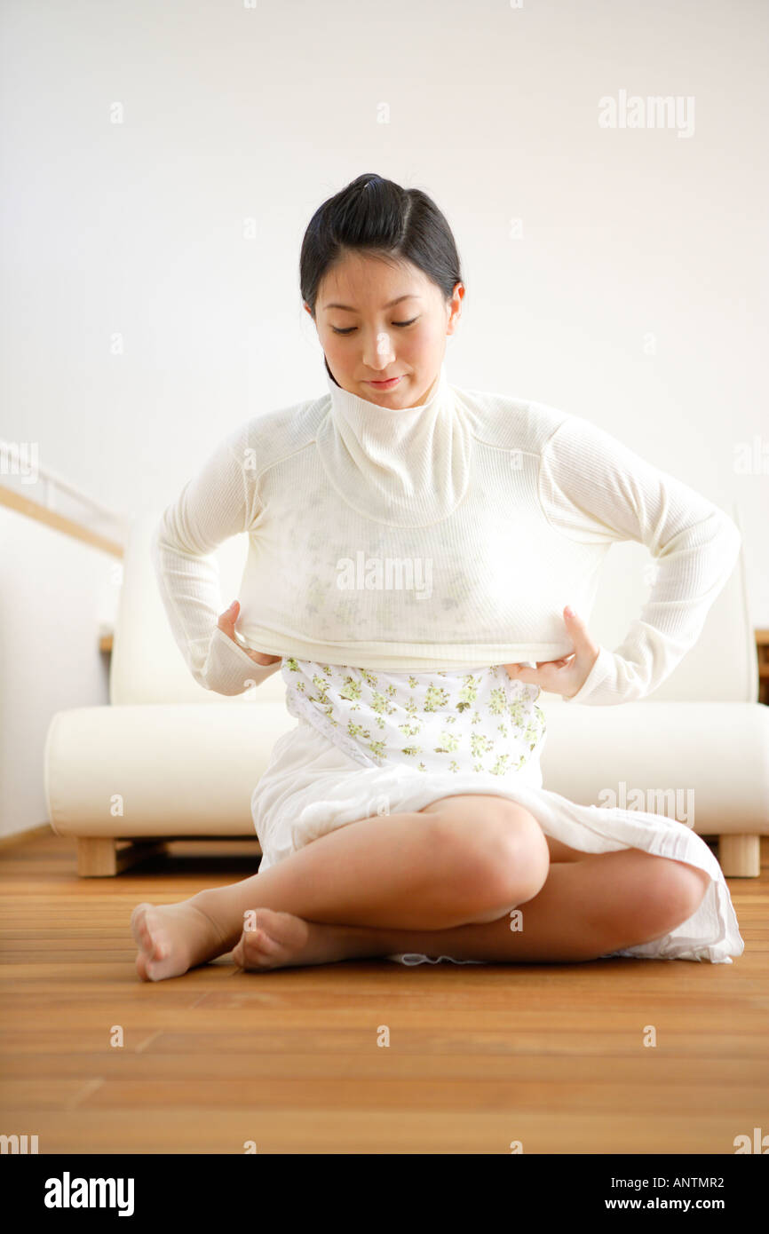 Young woman getting dressed Stock Photo - Alamy
