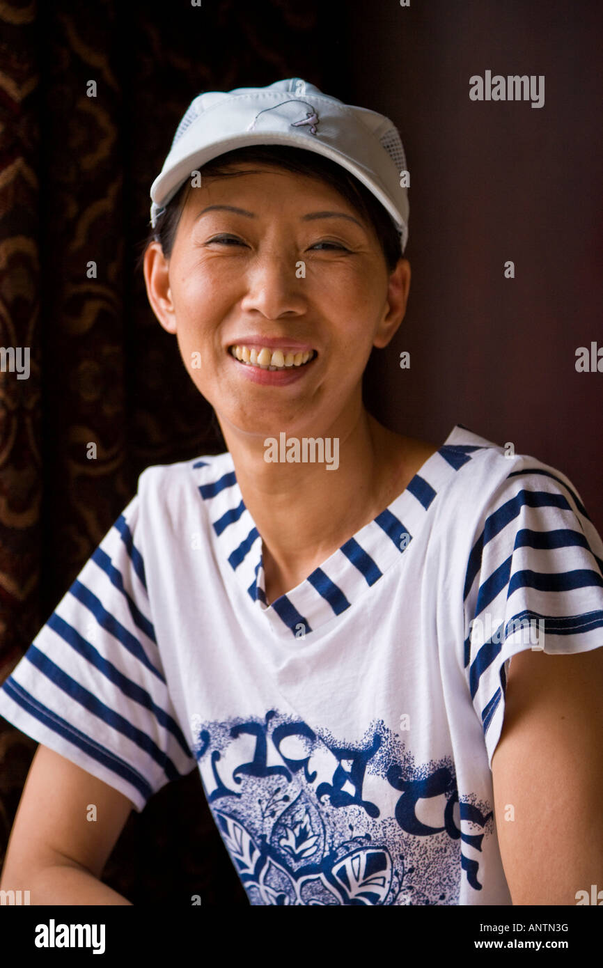 Middle Aged Asian Oriental Chinese Woman Wearing Cap Smiling Looking At