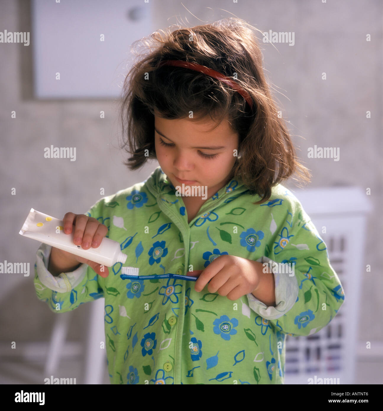 Little girl is putting toothpaste on her toothbrush Stock Photo - Alamy