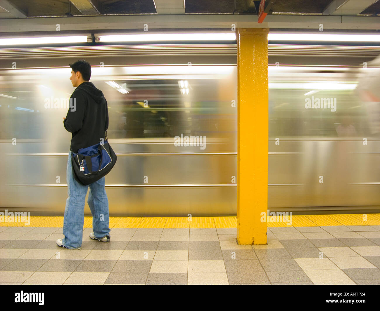 young man standing on subway platform and passing train new york usa ...