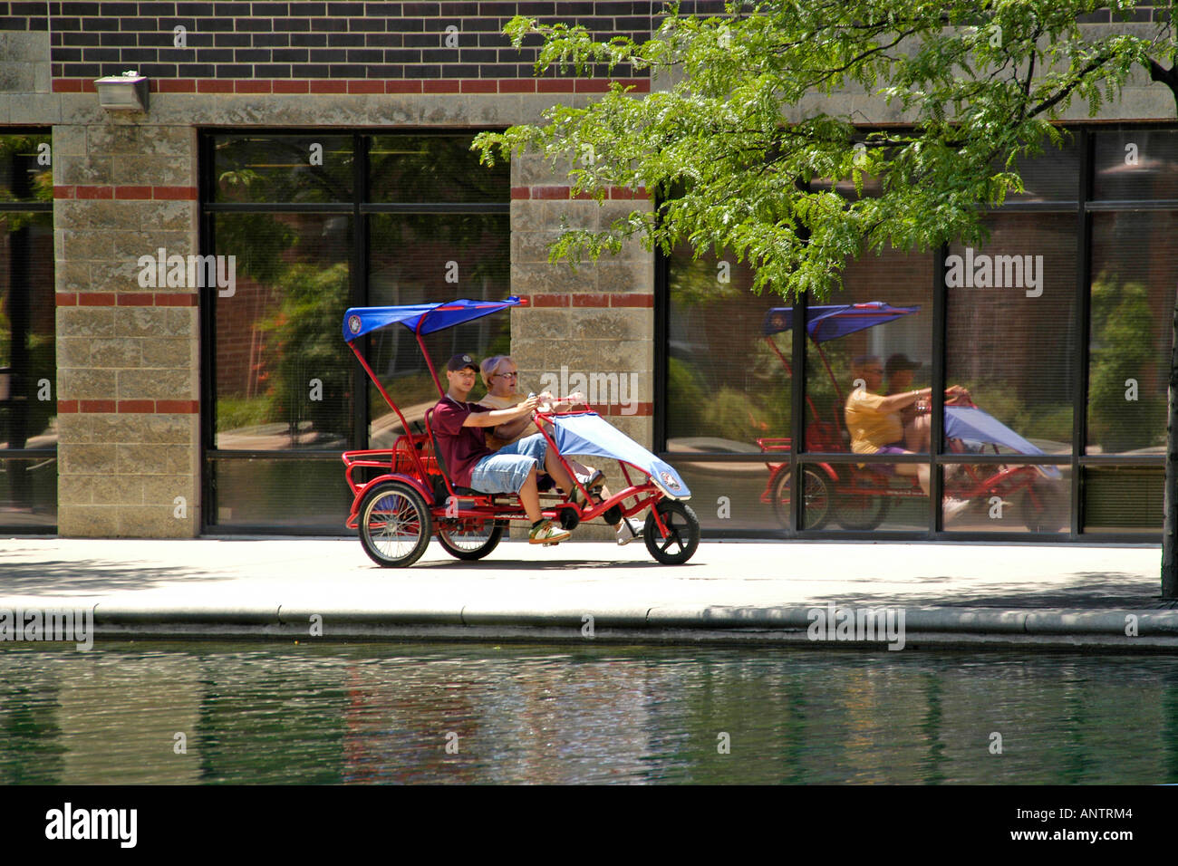 Family having fun on a tandem bicycle for four in the Indianapolis Park ...