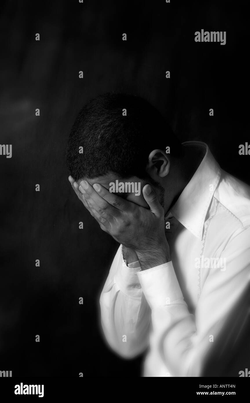 man hiding his face in regret Stock Photo - Alamy