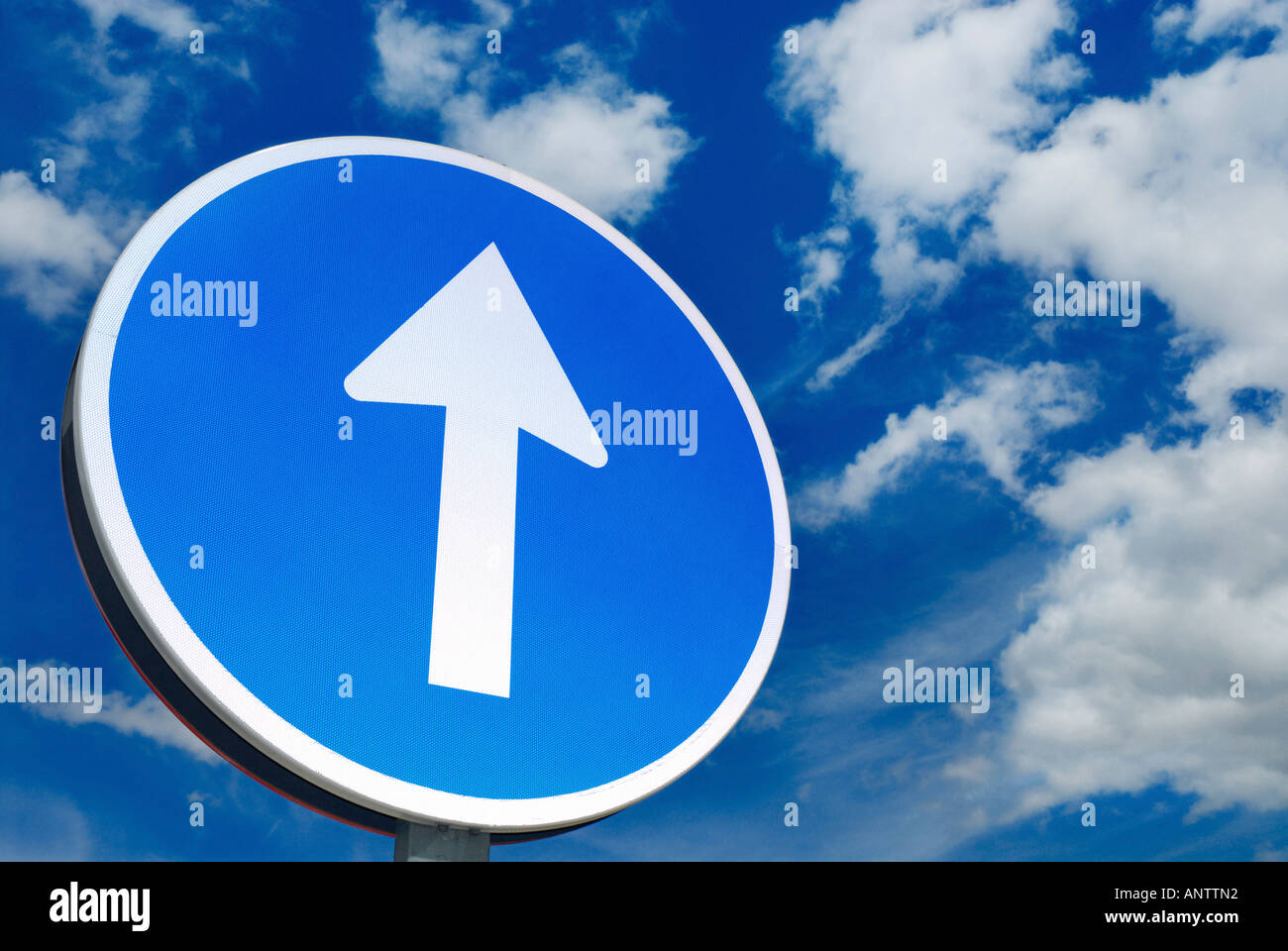 TRAFFIC SIGN ARROW CERCLE. AHEAD ONLY ON BLUE CLOUDS SKY BACKGROUND ...