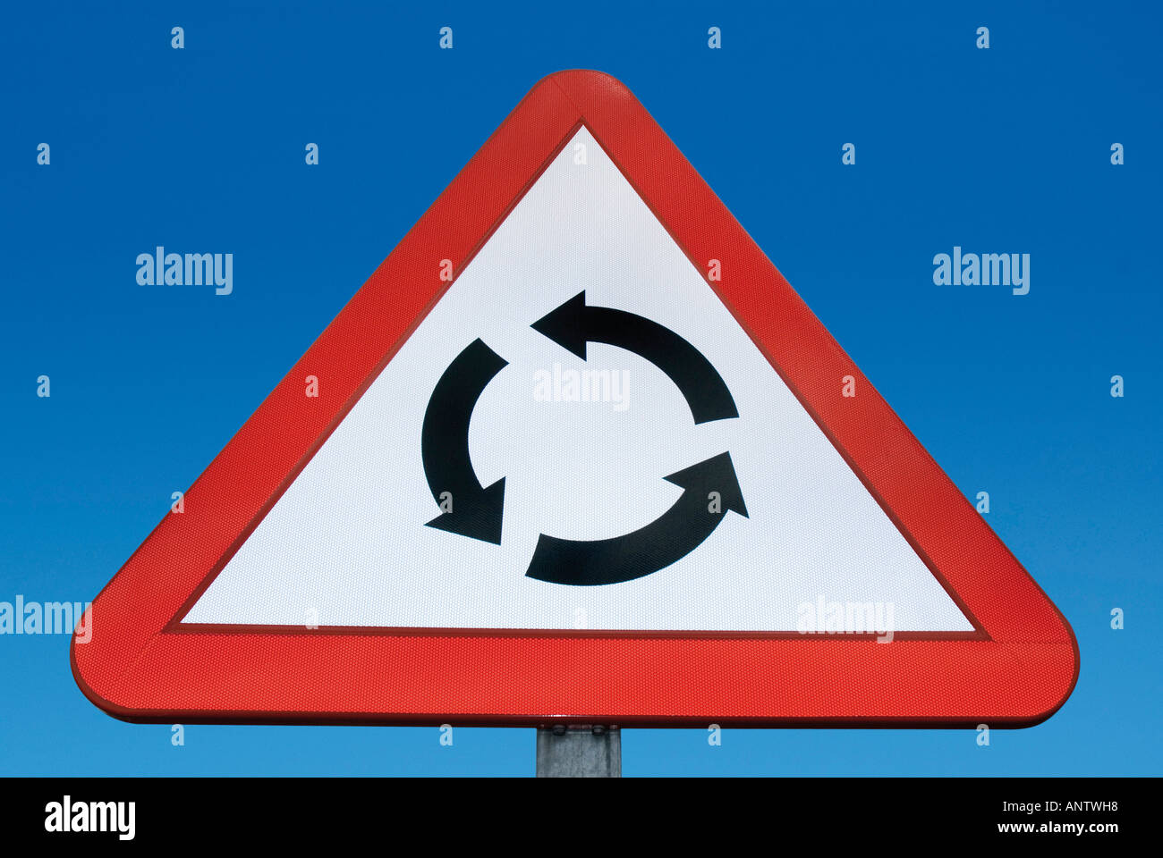 TRAFFIC SIGN. ROUNDABOUT TRIANGLE SIGN ON BLUE SKY BACKGROUND Stock Photo - Alamy